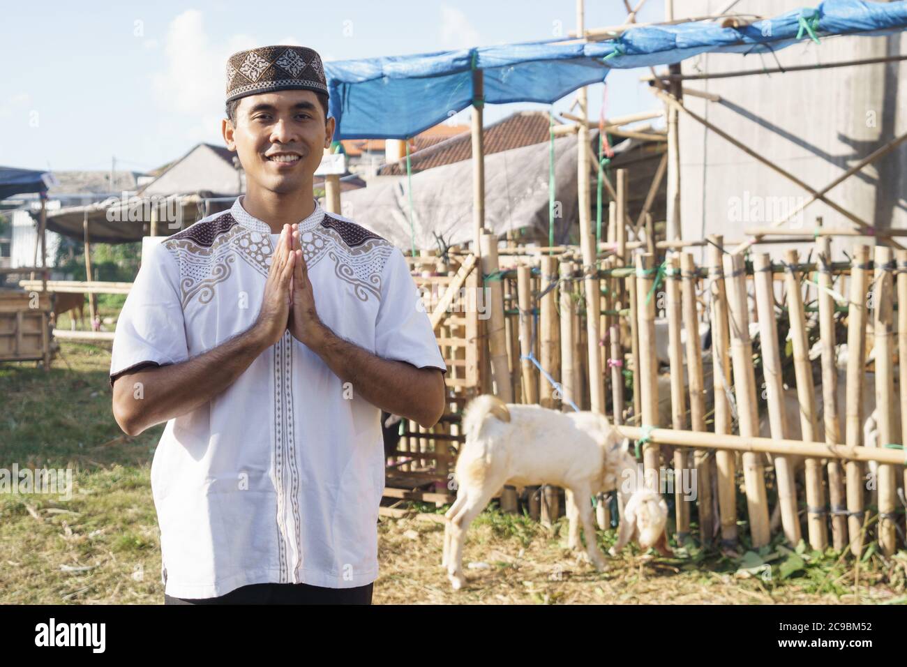 portrait of a man muslim standing in front of goat farm. eid adha ...