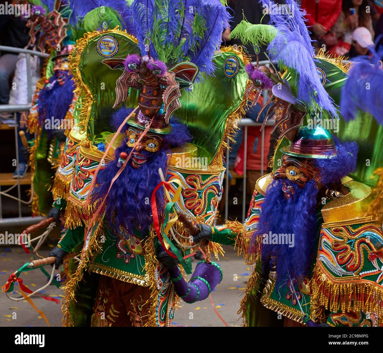 Masked morenada dancers in ornate costumes parade through the mining ...