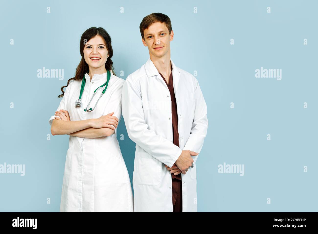 Two handsome looking young doctors in white robes. Man and woman Stock ...
