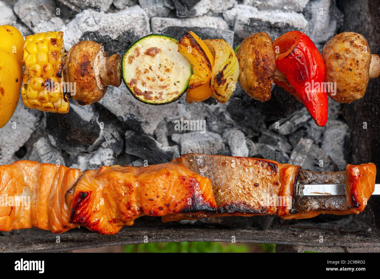 Variety of meat, fish and vegetable ingredients put on metal skewers ...