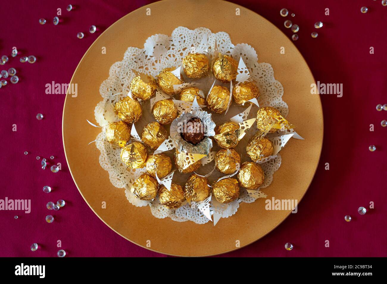 Chocolate confectionery in golden wrapping on golden plate Stock Photo ...