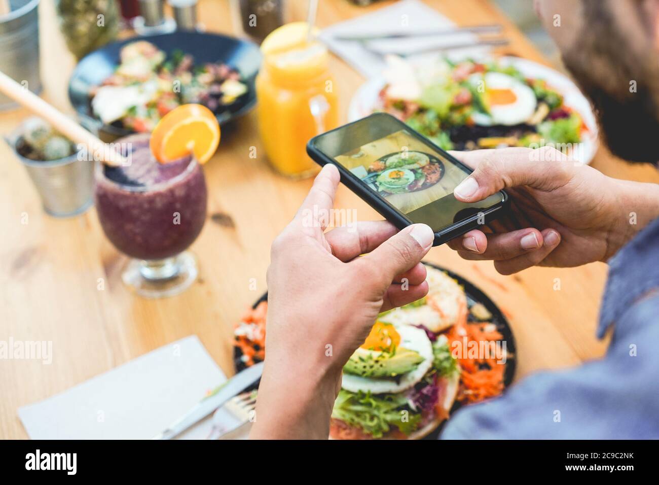 Influencer man eating brunch while making video and photos of dish with ...