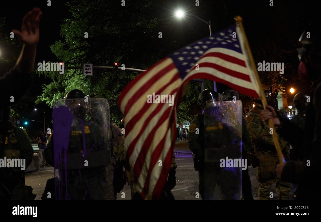 Portland, Oregon, U.S.A. 29th July, 2020. A protestor waves an American ...