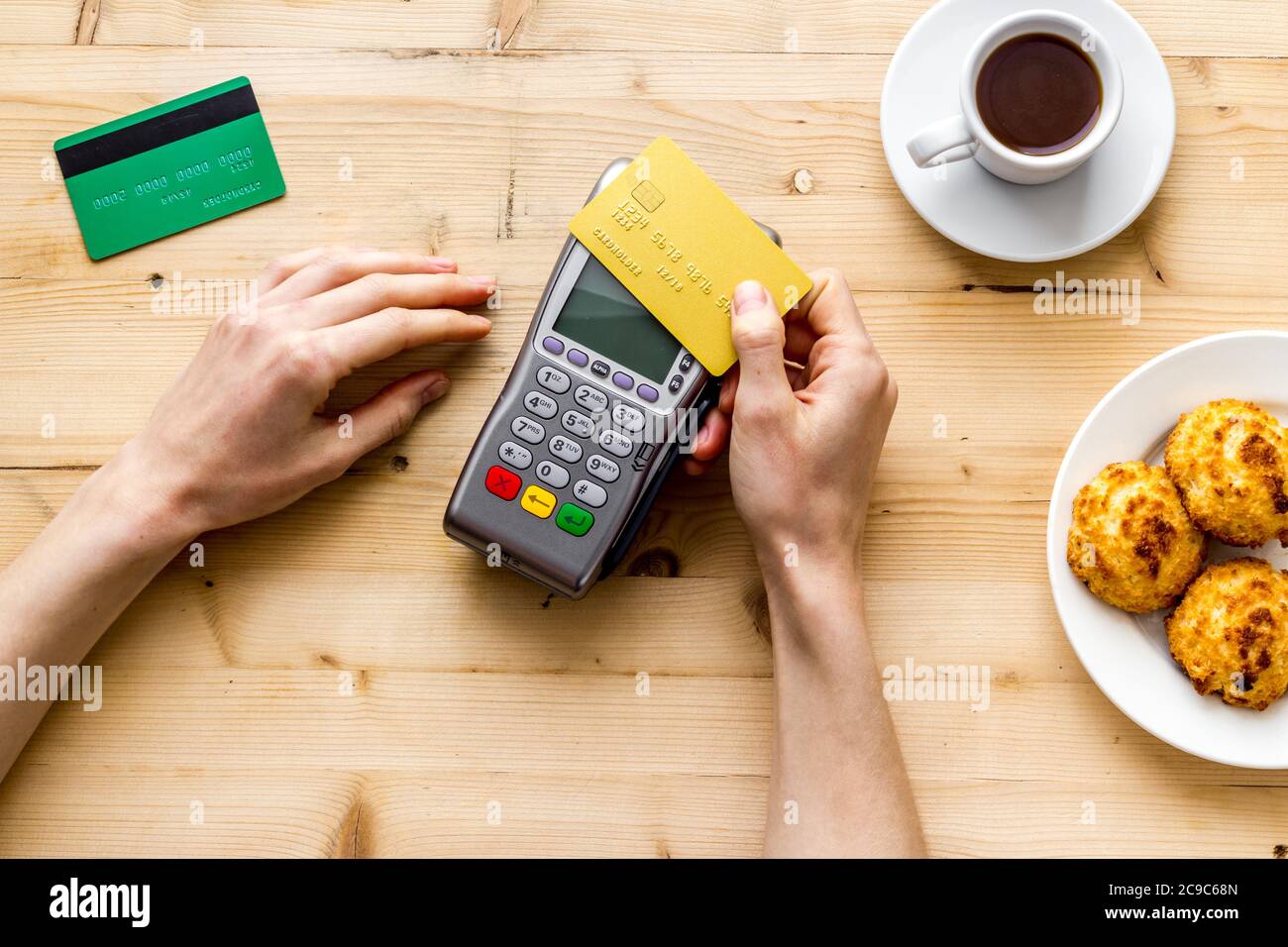 Payment transactions. Hand hold card near terminal on wooden cafe table ...