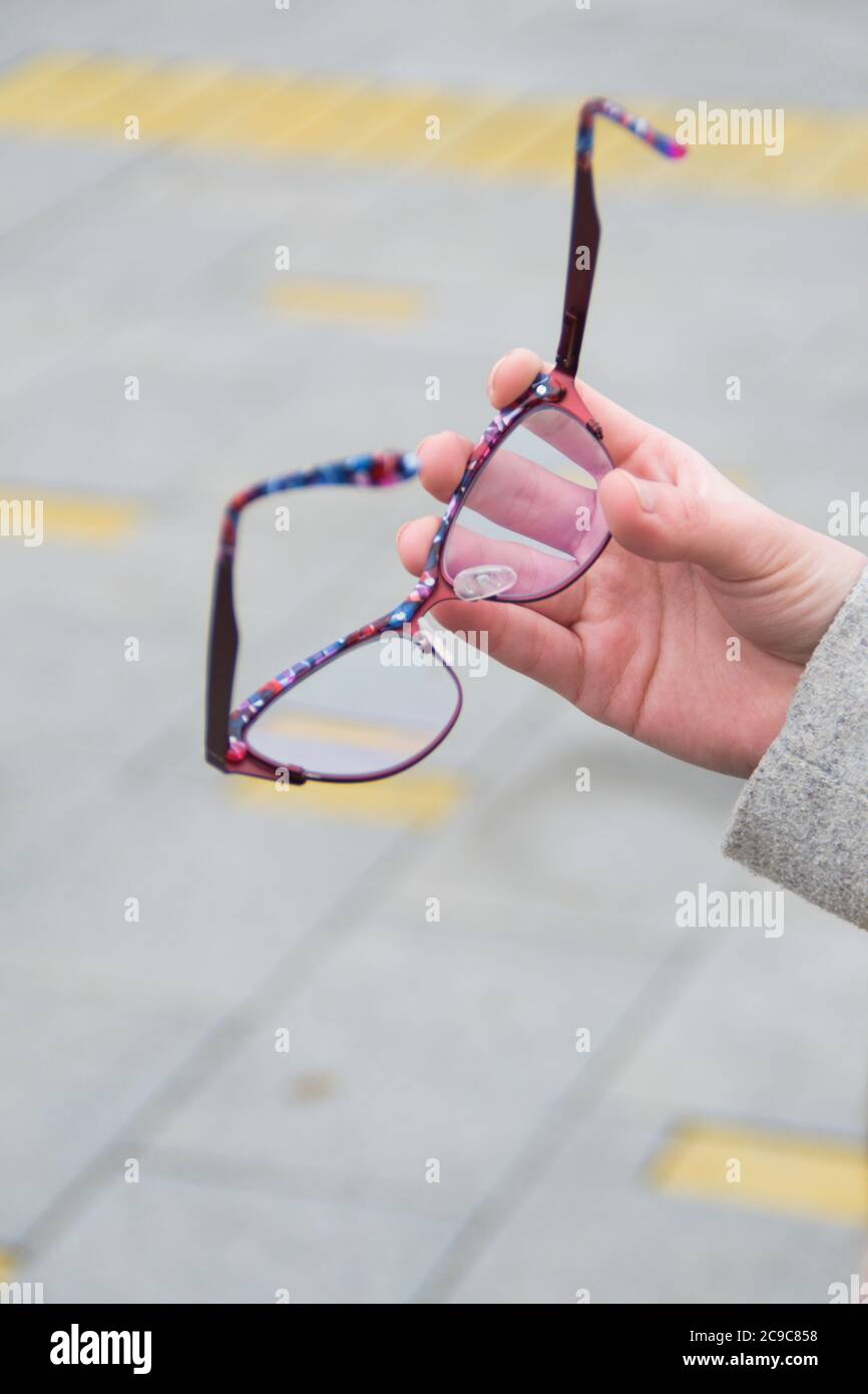 Reading glasses in woman's hand Stock Photo - Alamy