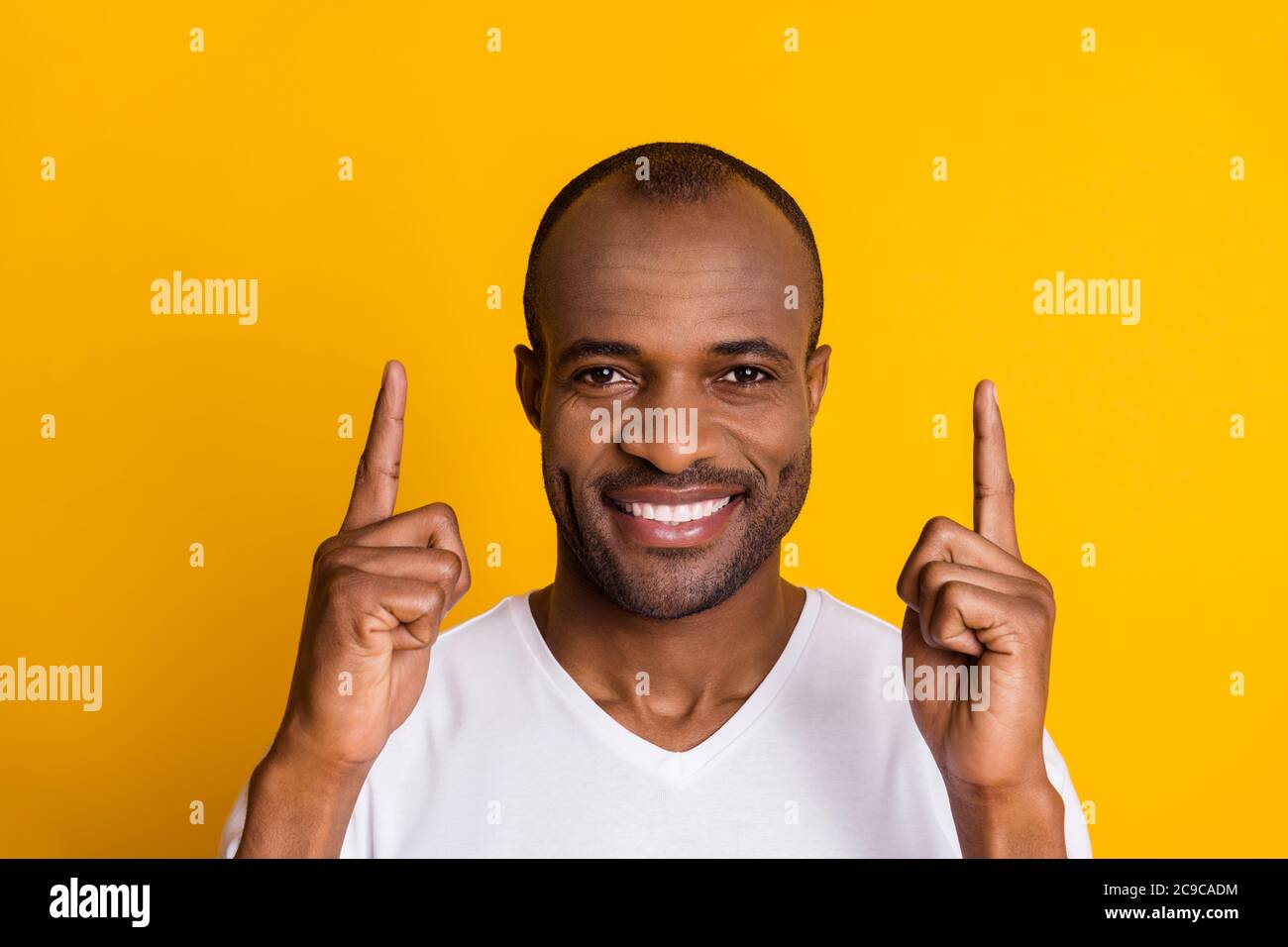 Positive cheerful afro american guy point index finger up copy space ...
