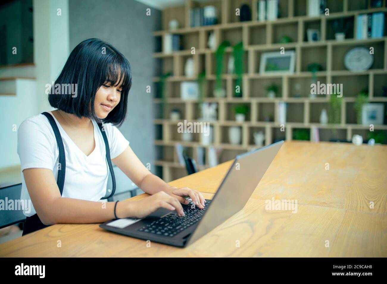 asian teenager working on laptop computer in home living room Stock ...