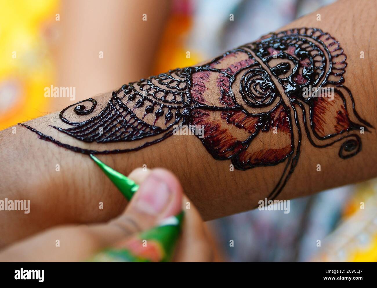 A Muslim girl gets her hands painted with traditional henna designs ...