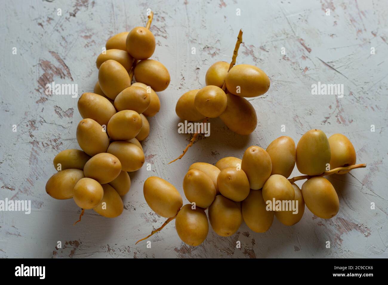 fresh dates fruit on texture white background Stock Photo - Alamy