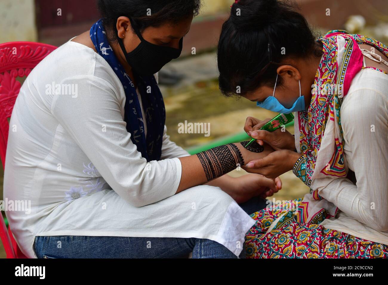A Muslim girl gets her hands painted with traditional henna designs ...