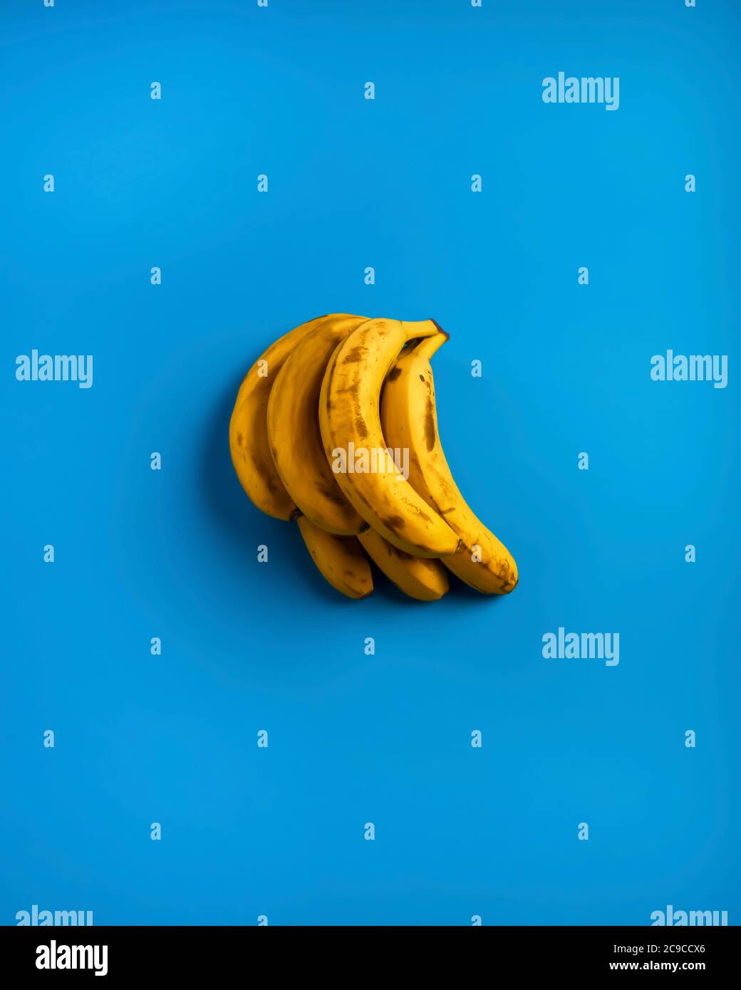 Bunch of brown spotted bananas isolated on blue background Stock Photo ...