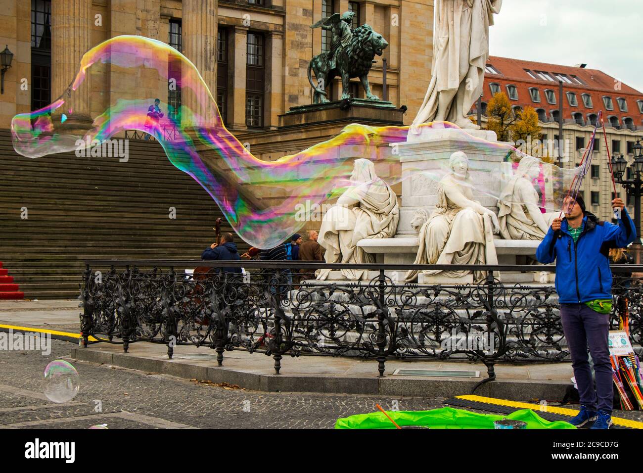 Soap bubbles in the street of Berlin, Germany. Man entertain people and ...