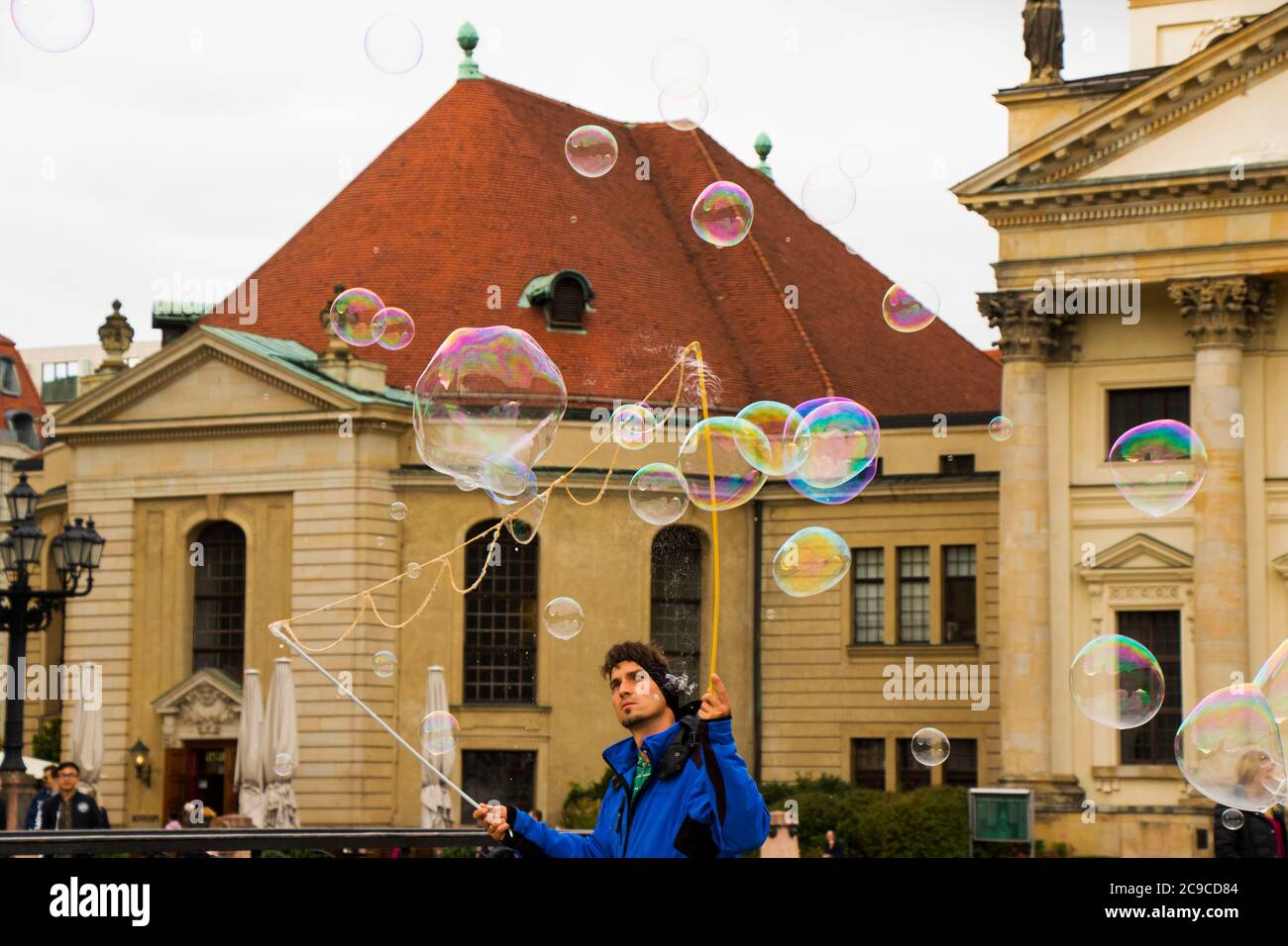 Soap bubbles in the street of Berlin, Germany. Man entertain people and ...