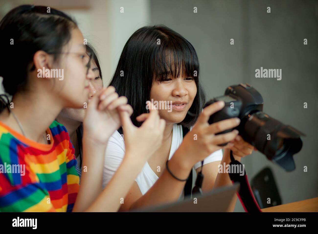 asian teenager looking on back screen of dslr camera in hand Stock ...