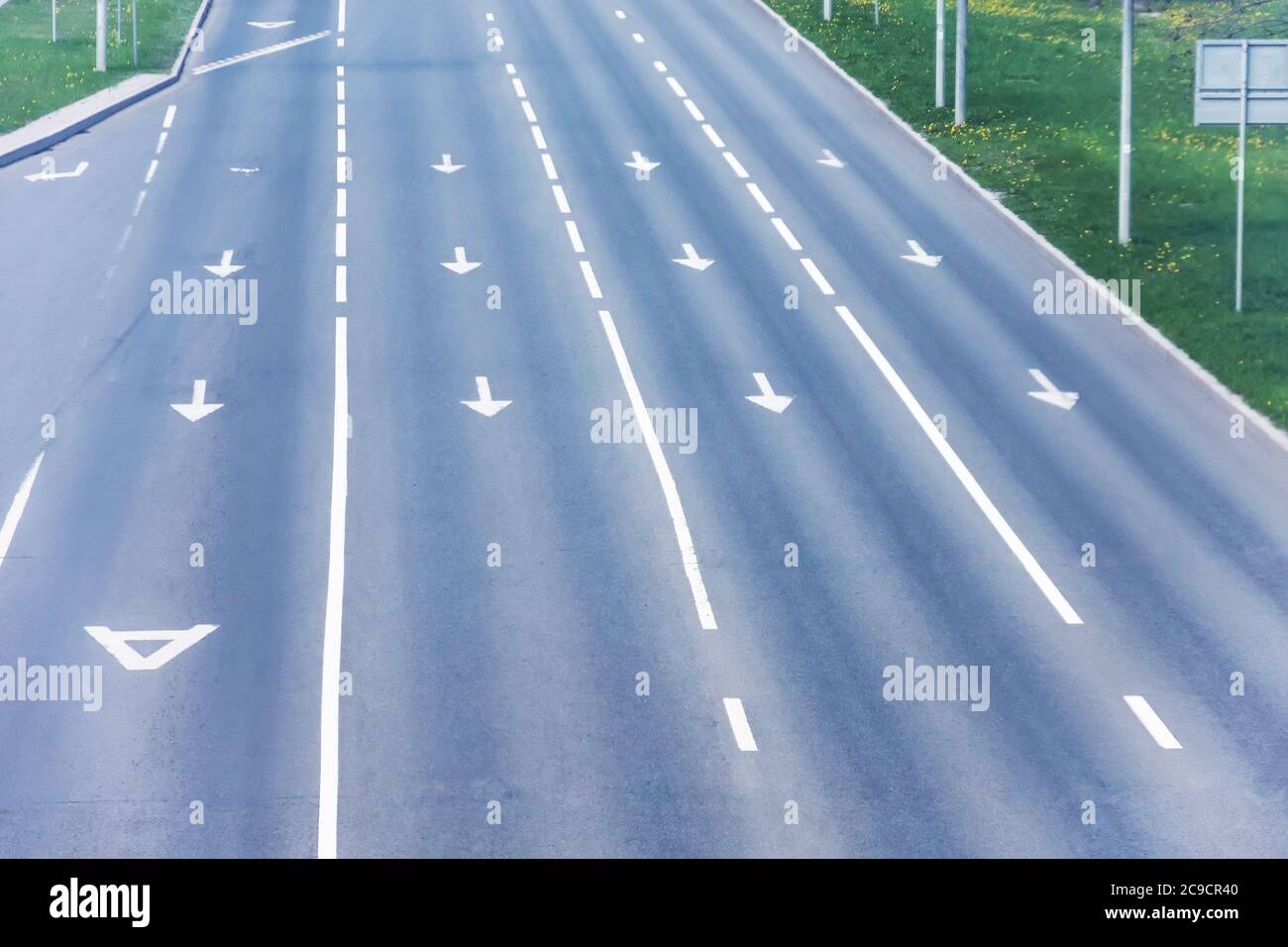 Four paved lanes with traffic arrows directing traffic in various ...