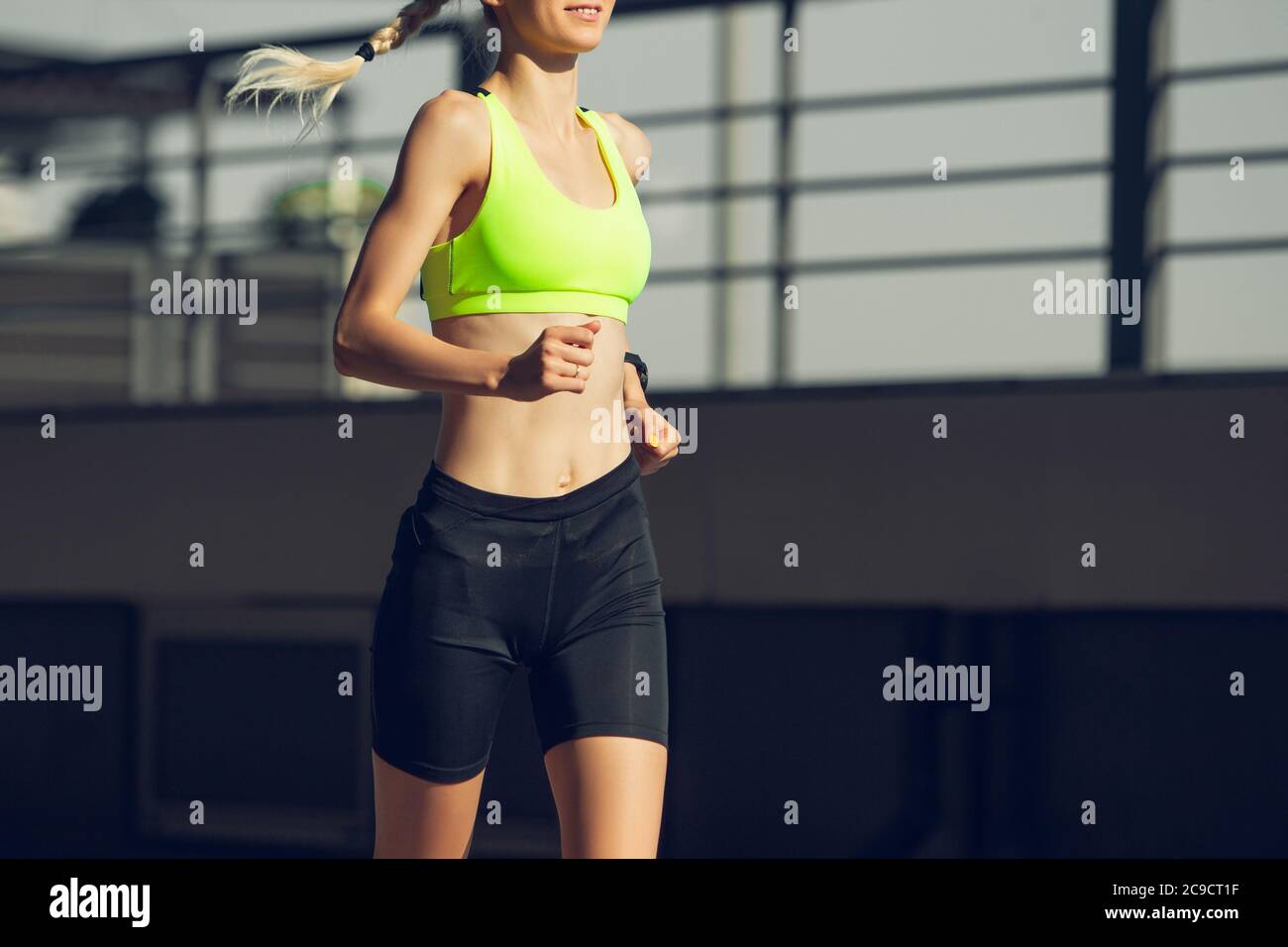 Strong. Female runner, athlete training outdoors. Professional runner ...