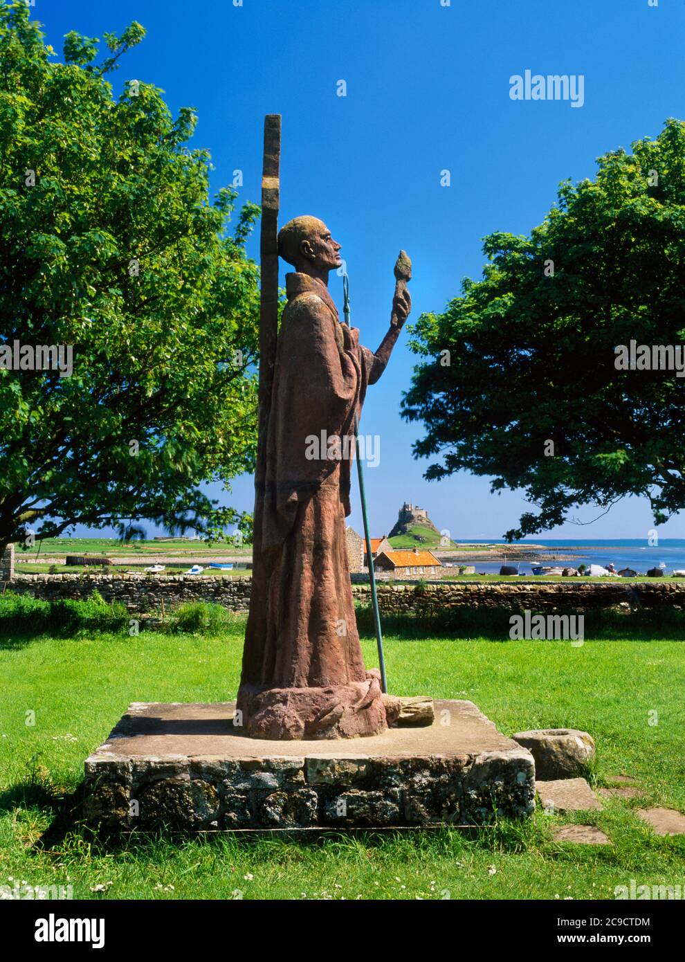 Modern statue of St Aidan with a Celtic cross halo & holding a torch ...