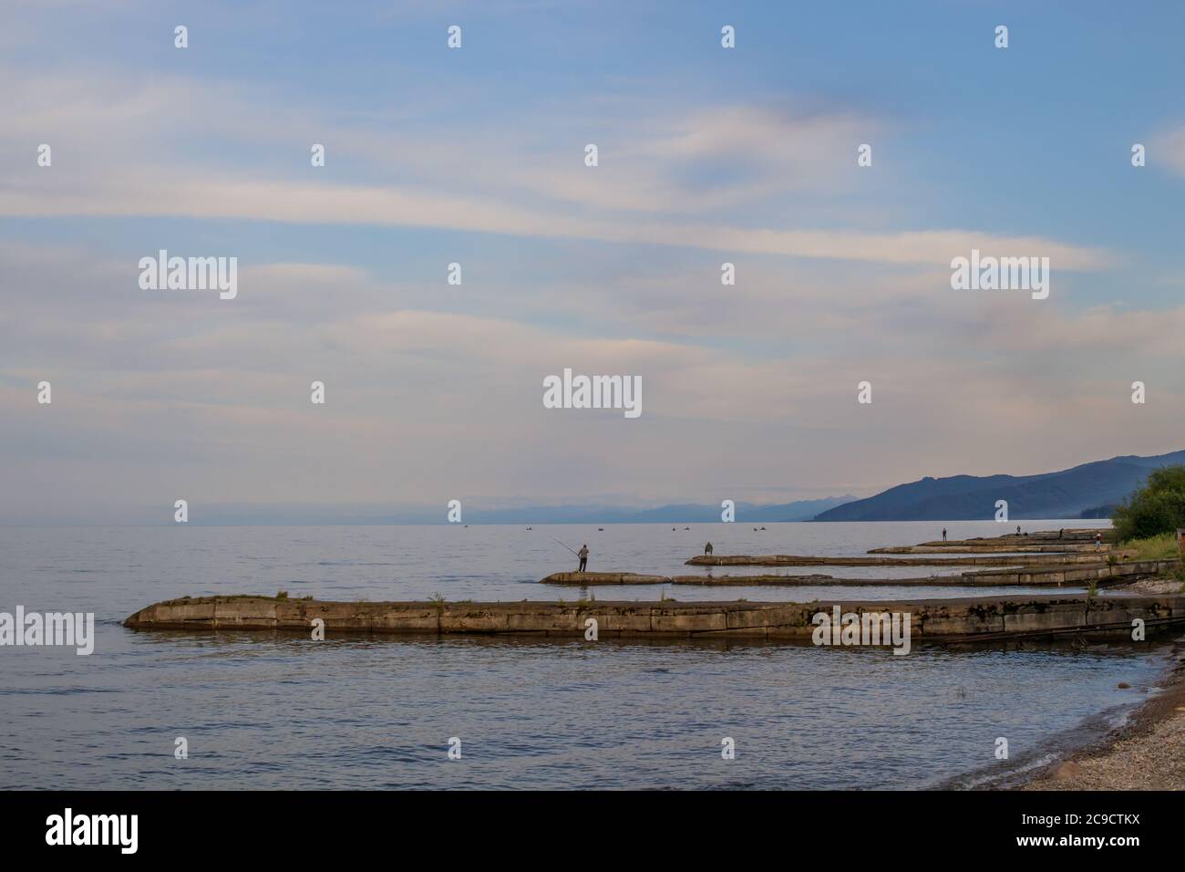 Lake Baikal. On breakwaters, fishermen catch fish with fishing rods ...