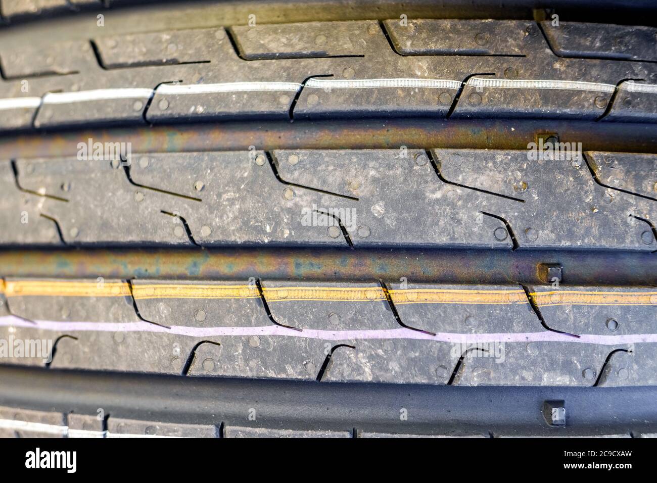 Focused on closeup of new car tires with tread marks for good traction ...