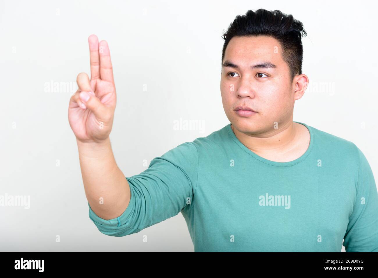 Portrait of young handsome overweight Asian man touching something ...
