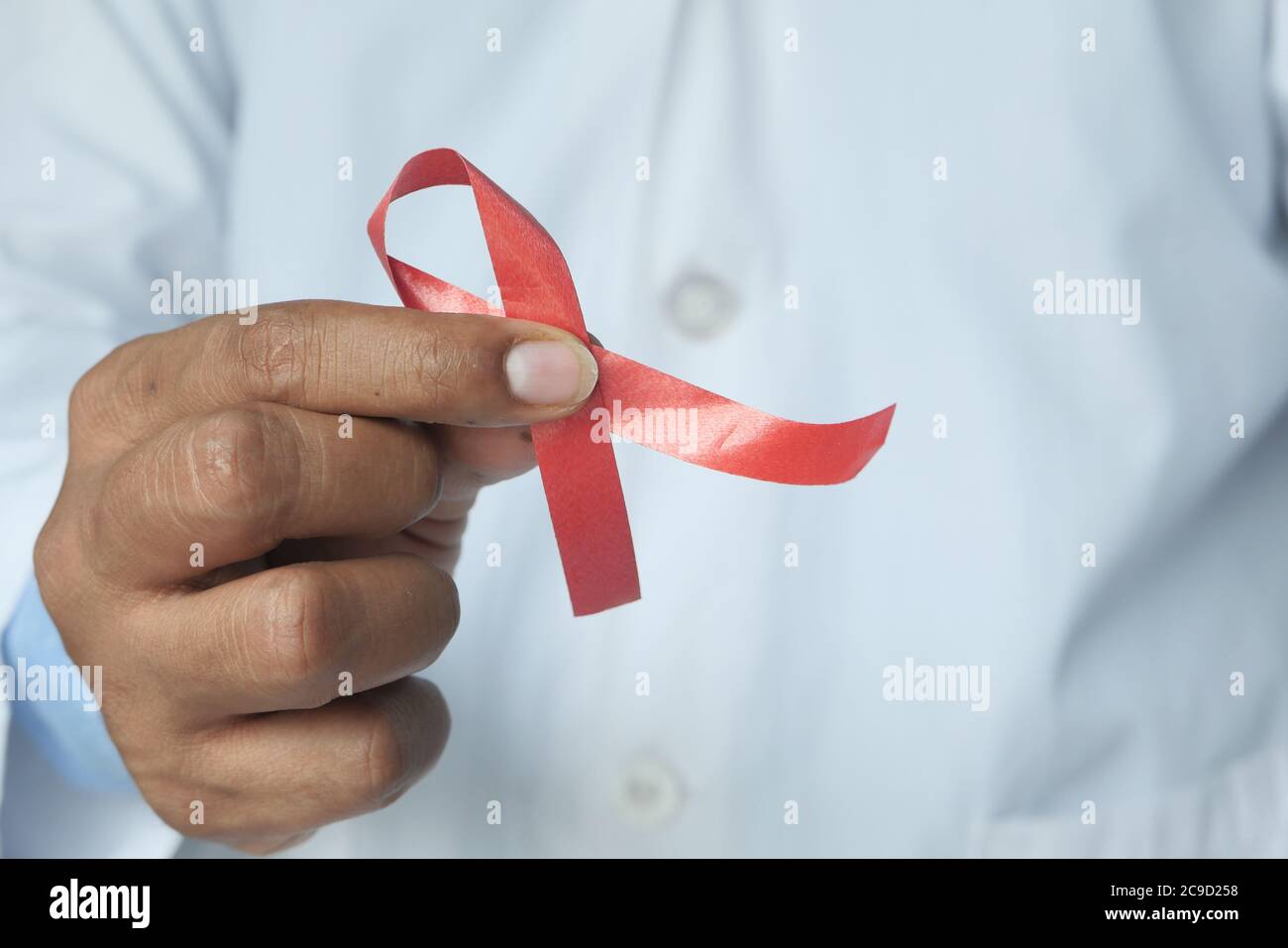 hand holding red HIV ribbon with copy space Stock Photo - Alamy