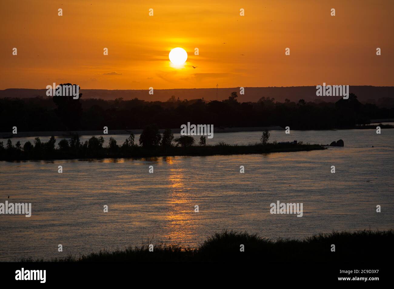 The Niger river flows at sunset through the capital city of Niamey ...
