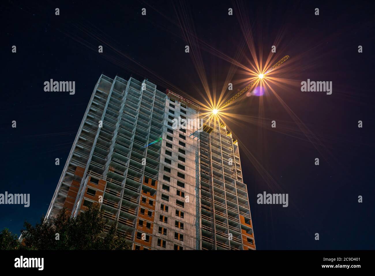 Tower crane at a construction site at night. Night view of construction ...