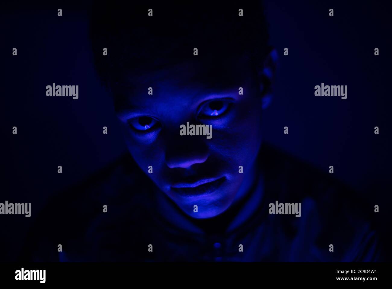 Portrait of young boy in dark room Stock Photo - Alamy