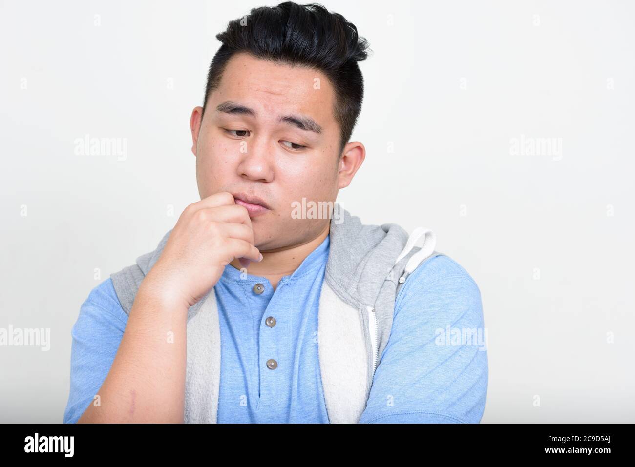 Portrait of stressed young overweight Asian man thinking Stock Photo ...