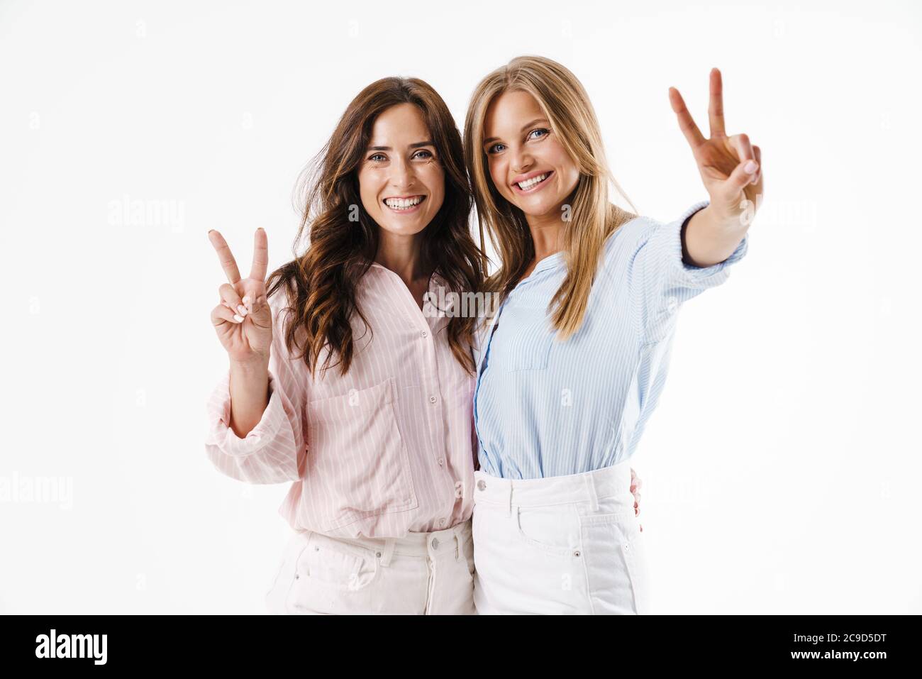Image of smiling beautiful two women gesturing peace sign while hugging ...