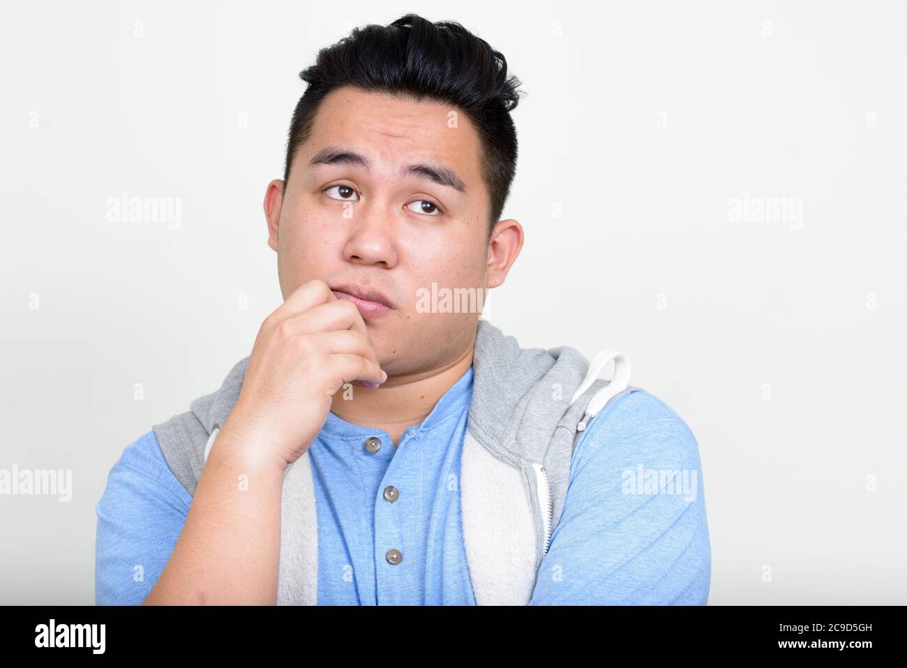 Portrait of stressed young overweight Asian man thinking Stock Photo ...