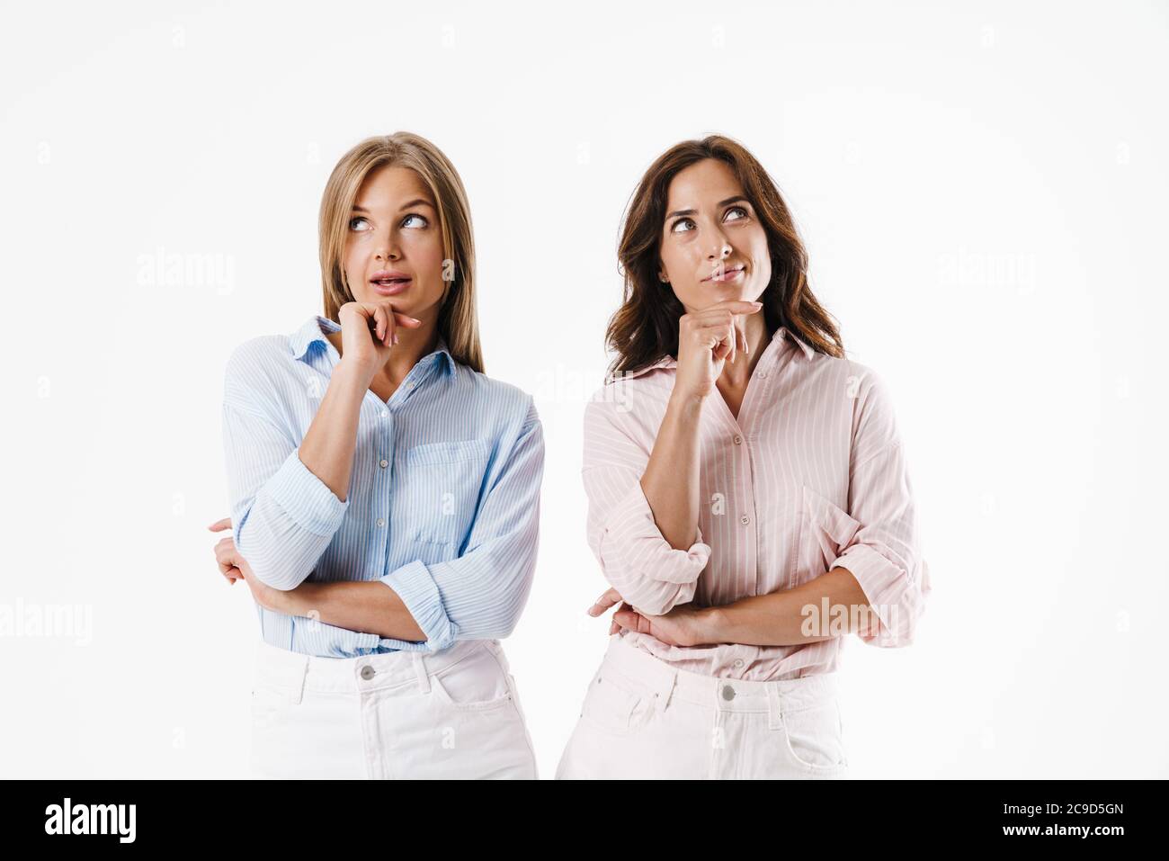 Image of thinking attractive two women looking upward while posing at ...