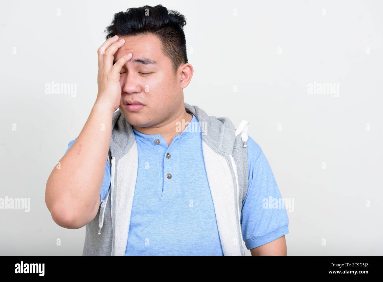 Portrait of stressed young overweight Asian man getting bad news Stock ...