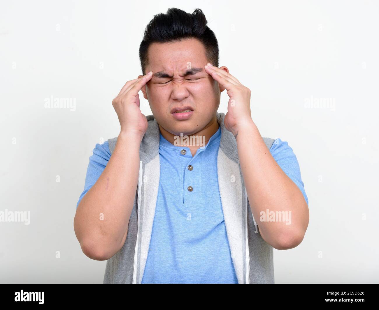 Portrait of stressed young overweight Asian man having headache Stock ...