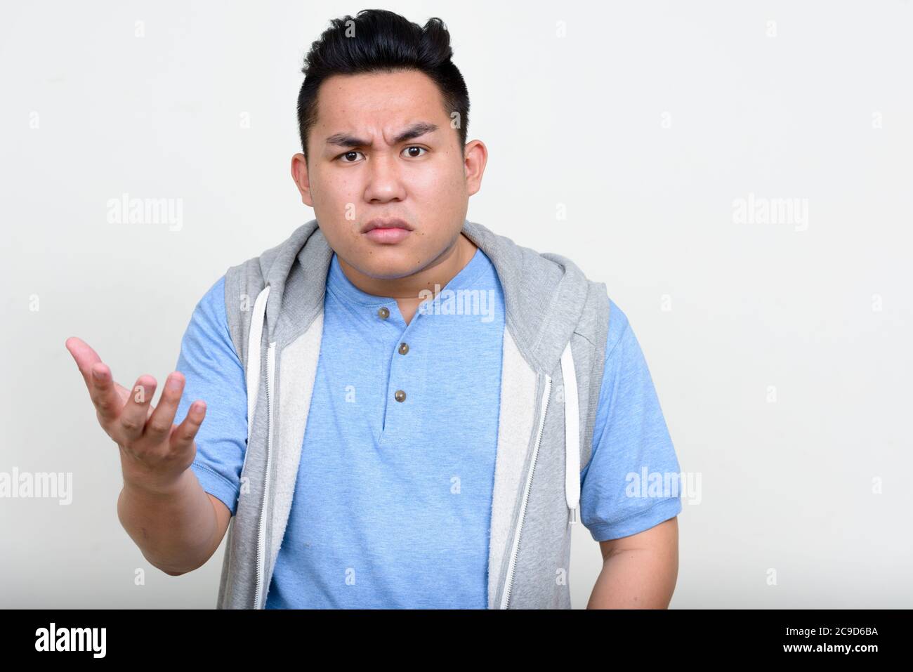 Portrait of stressed young overweight Asian man looking angry Stock ...