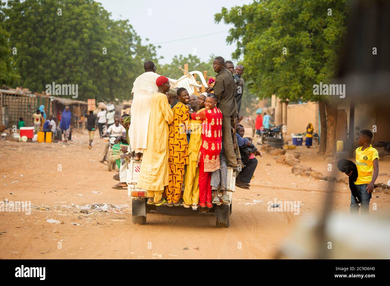 A crowded public transport taxi traverses a village road in Tahoua ...