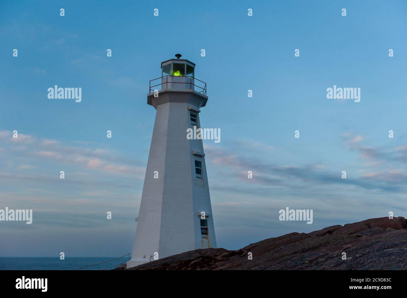 An onshore lighthouse built on a rocky foundation with steps and a ...