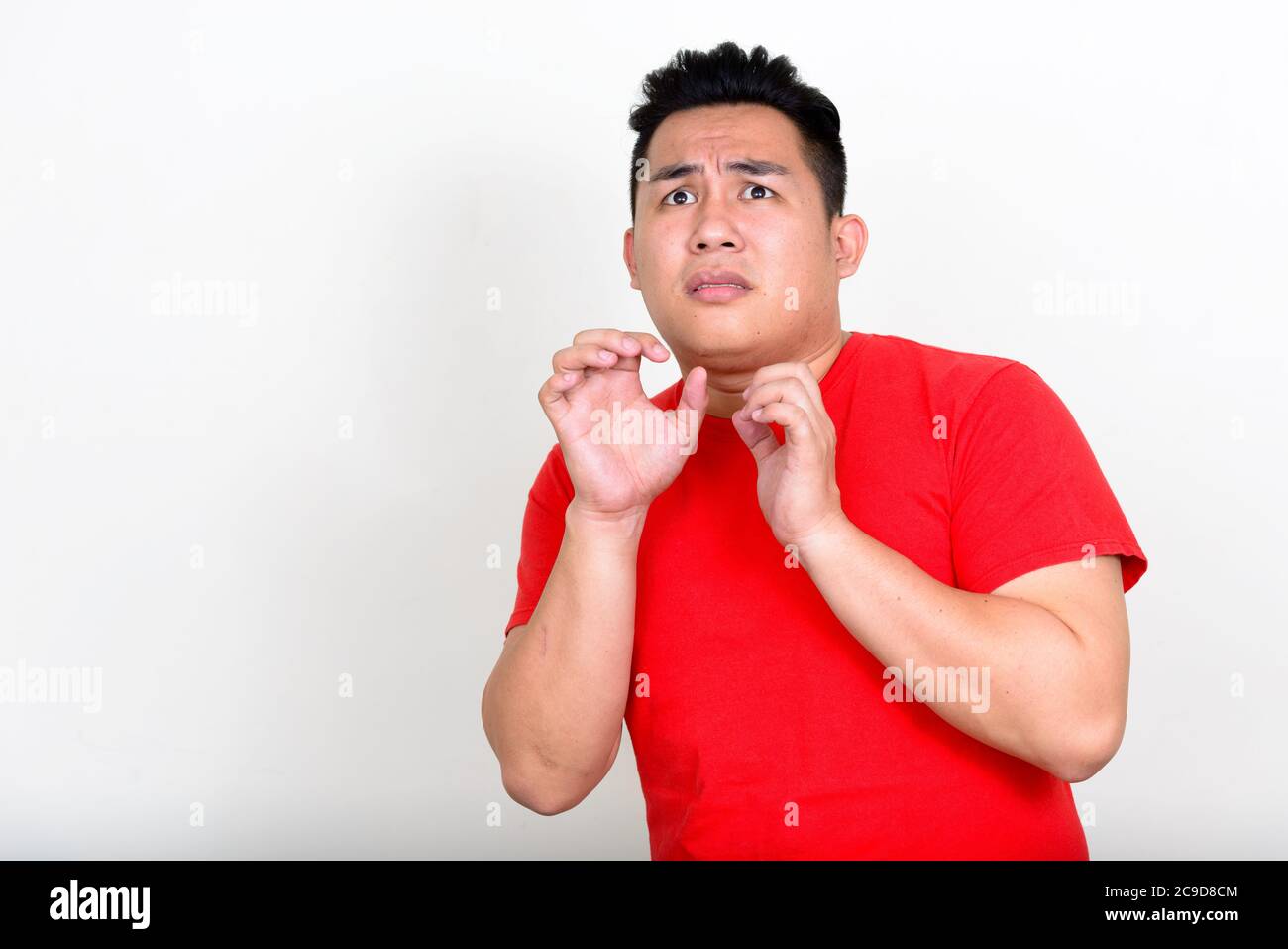 Portrait of stressed young overweight Asian man looking scared Stock ...