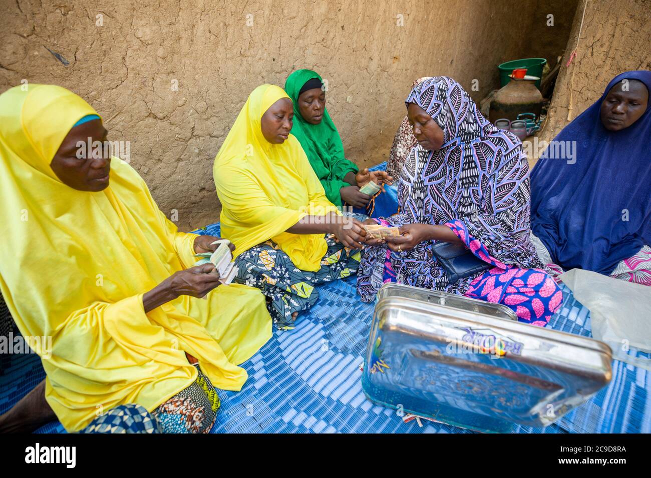 Women wearing traditional colourful Islamic dress attend a microfinance ...