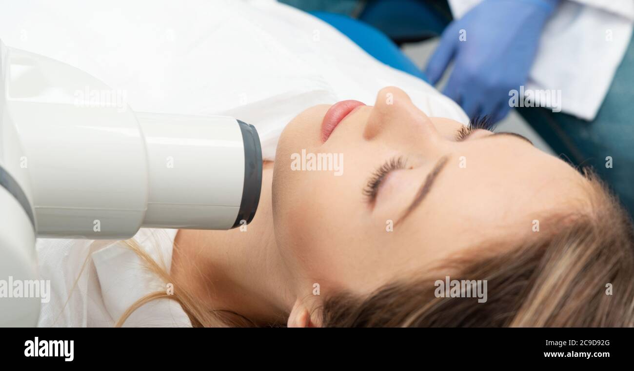 Dentist takes an x-ray picture of the tooth. Patient lying on chair ...