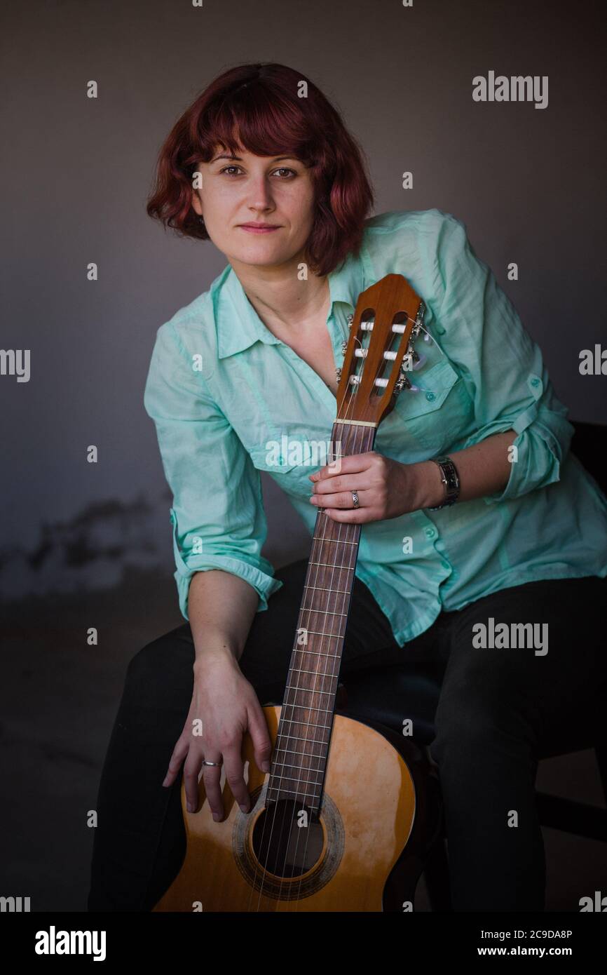 Close-up portrait of a cute girl hugging classical guitar. Guitar ...
