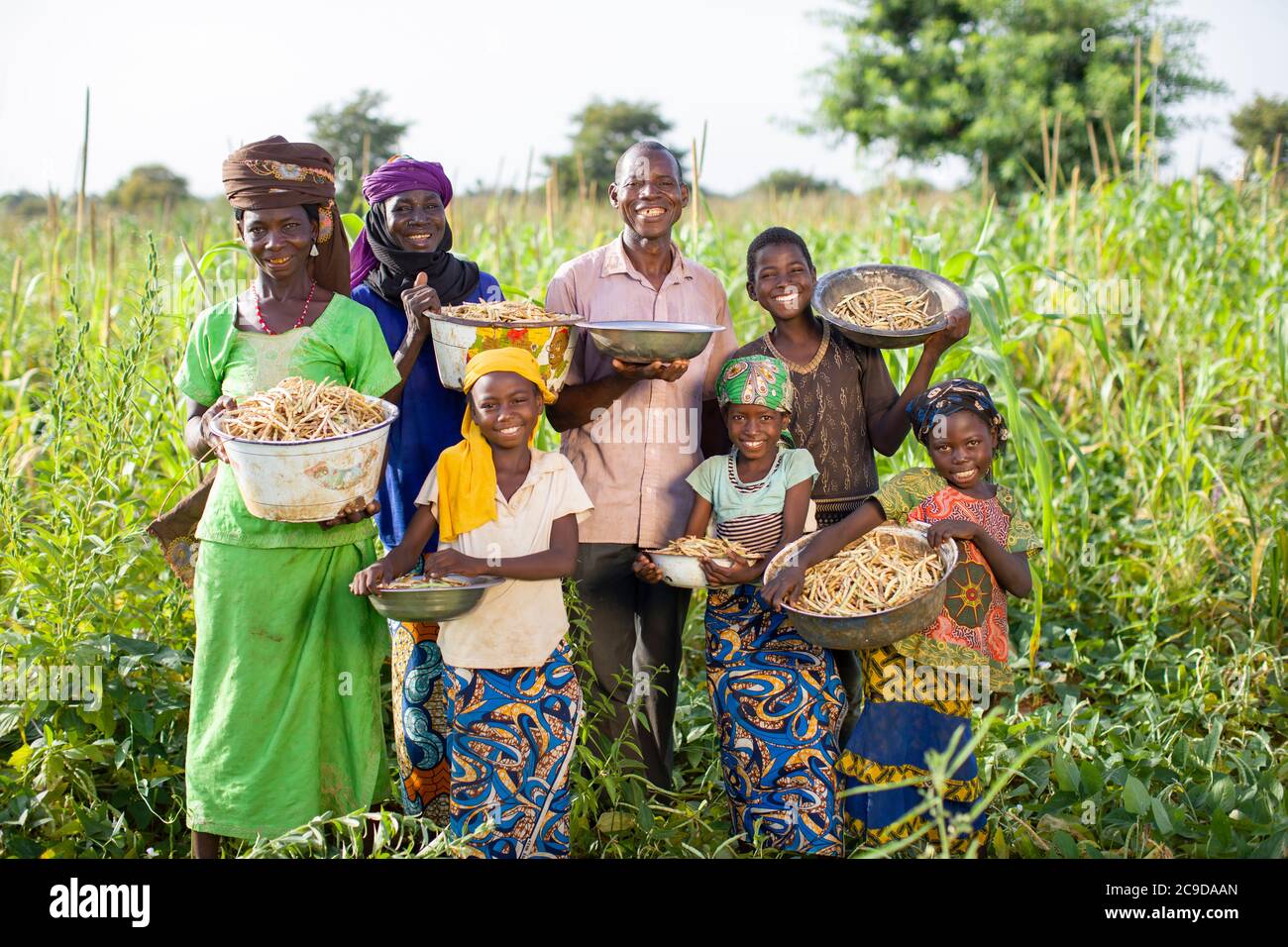 Portrait of a farmer family with their cowpea harvest in Tahoua Region ...