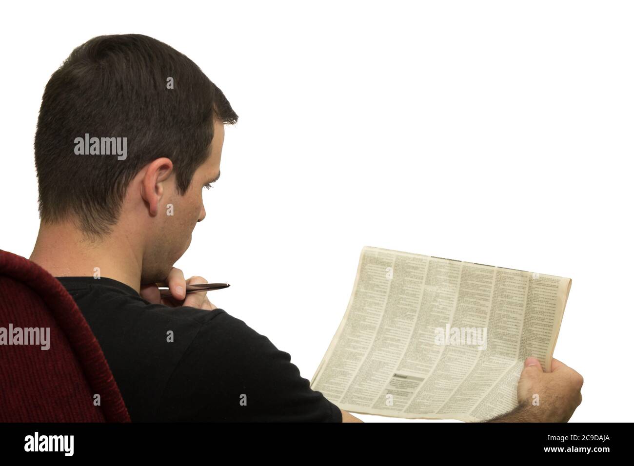 Young man in a chair reading a newspaper with an advertisement - in ...