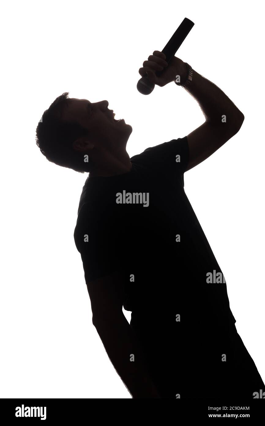 Young man singing into the microphone, raising his hands - silhouette Stock Photo - Alamy