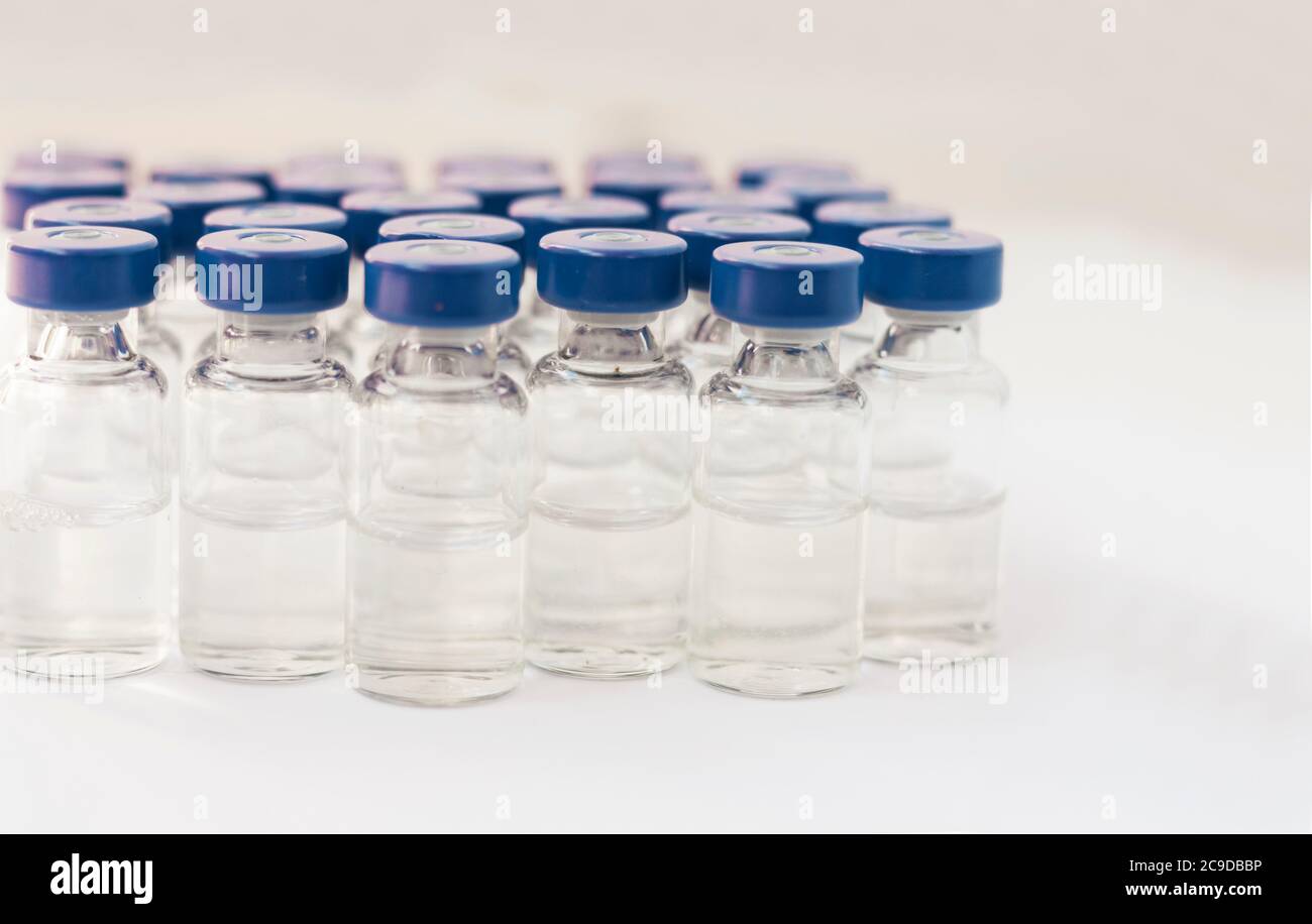 Glass medicine bottles with injection fluid with blue aluminium caps ...