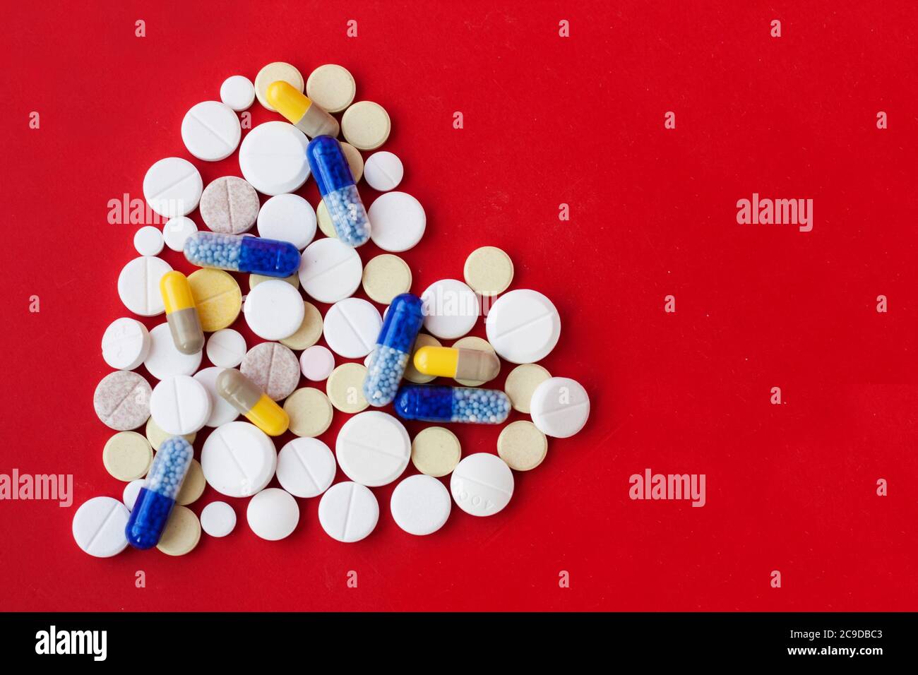 Heap of colorful pills in the shape of a heart, tablets and capsules ...