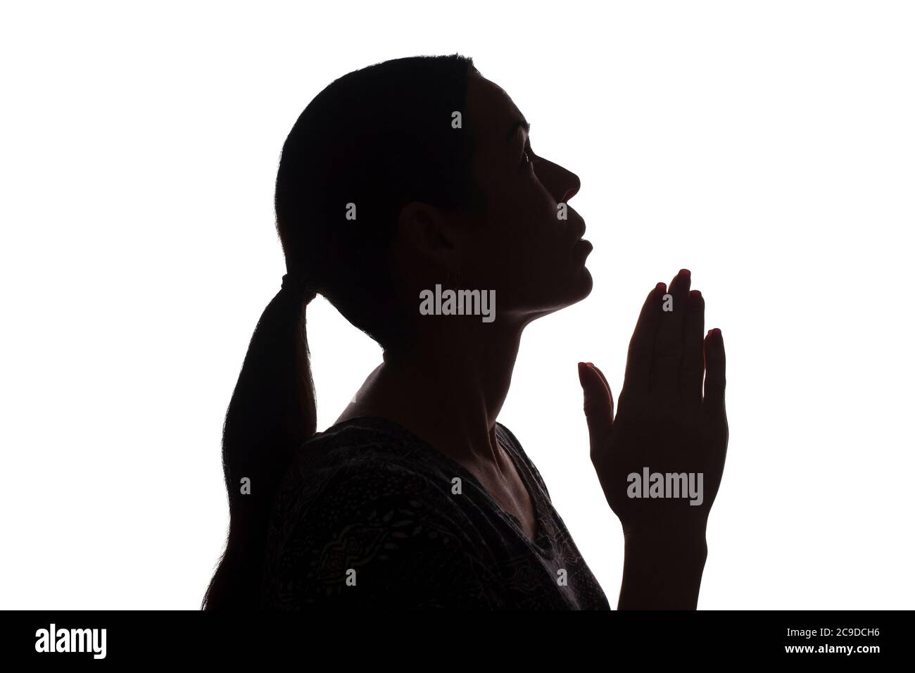 Young woman looking up with hope and request - silhouette of a side ...