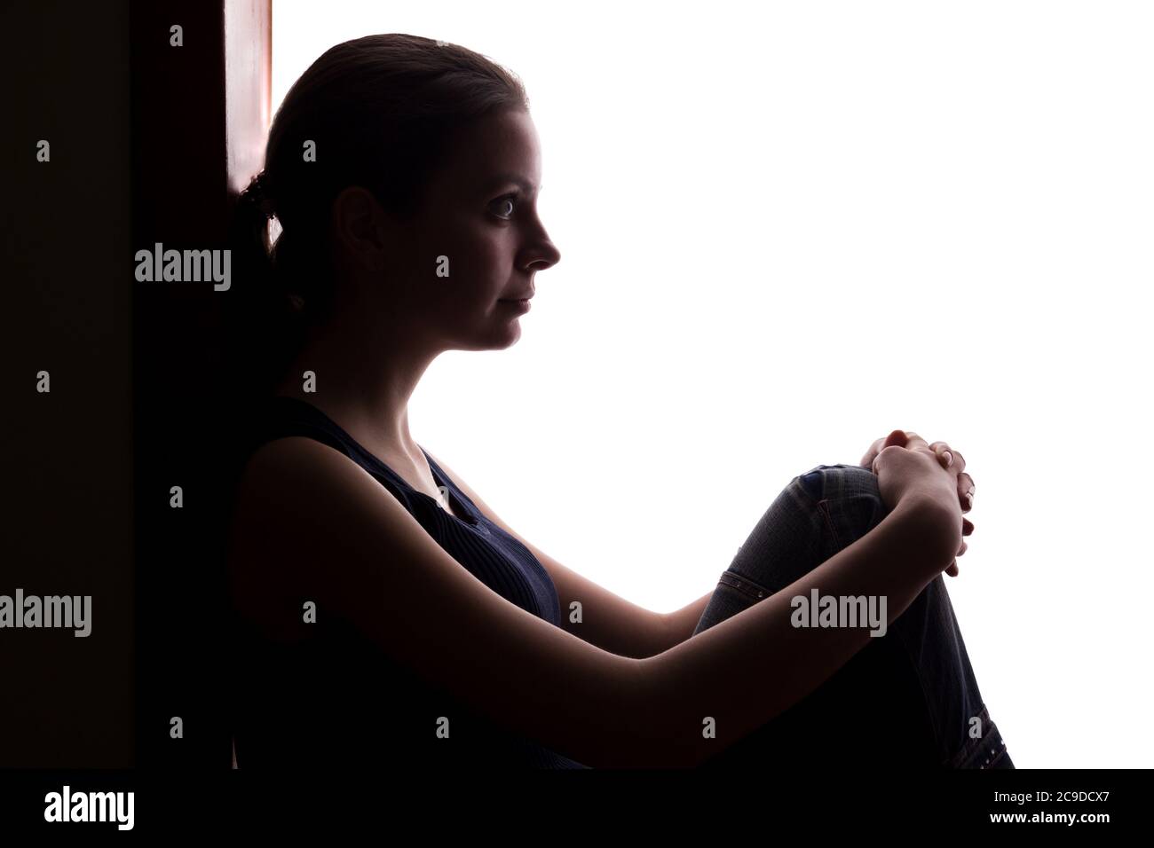 Young woman with grief dropped his arms - silhouette Stock Photo - Alamy