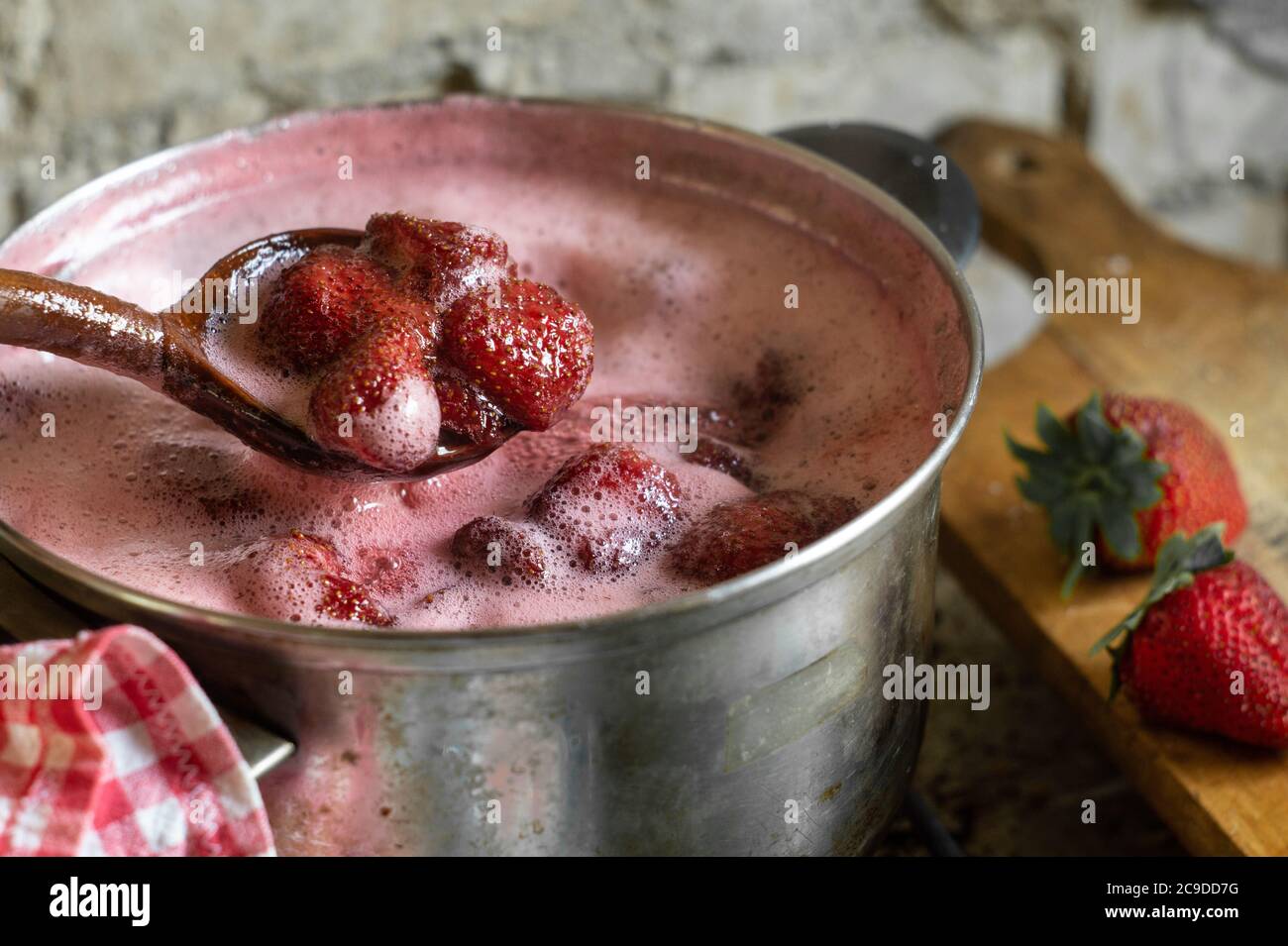 Cooking strawberry jam. Berries with sugar boiling in a pan forming a ...