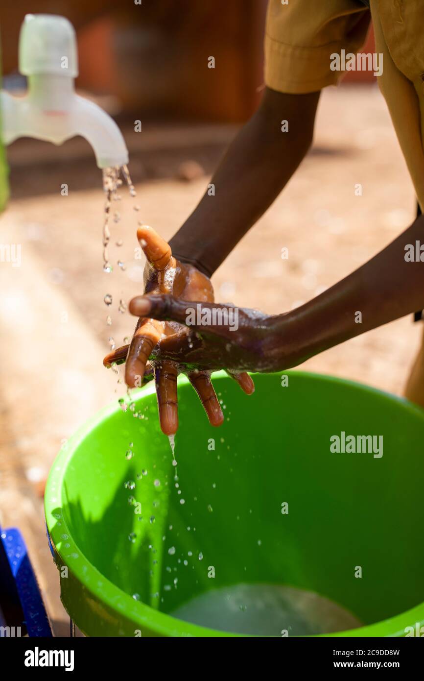 A child washes his hands at a hand washing station at his school in ...
